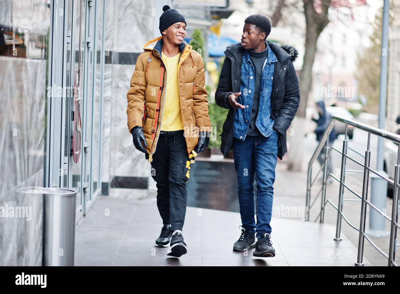 Two african male friends talking together, wear on jackets at cold ...