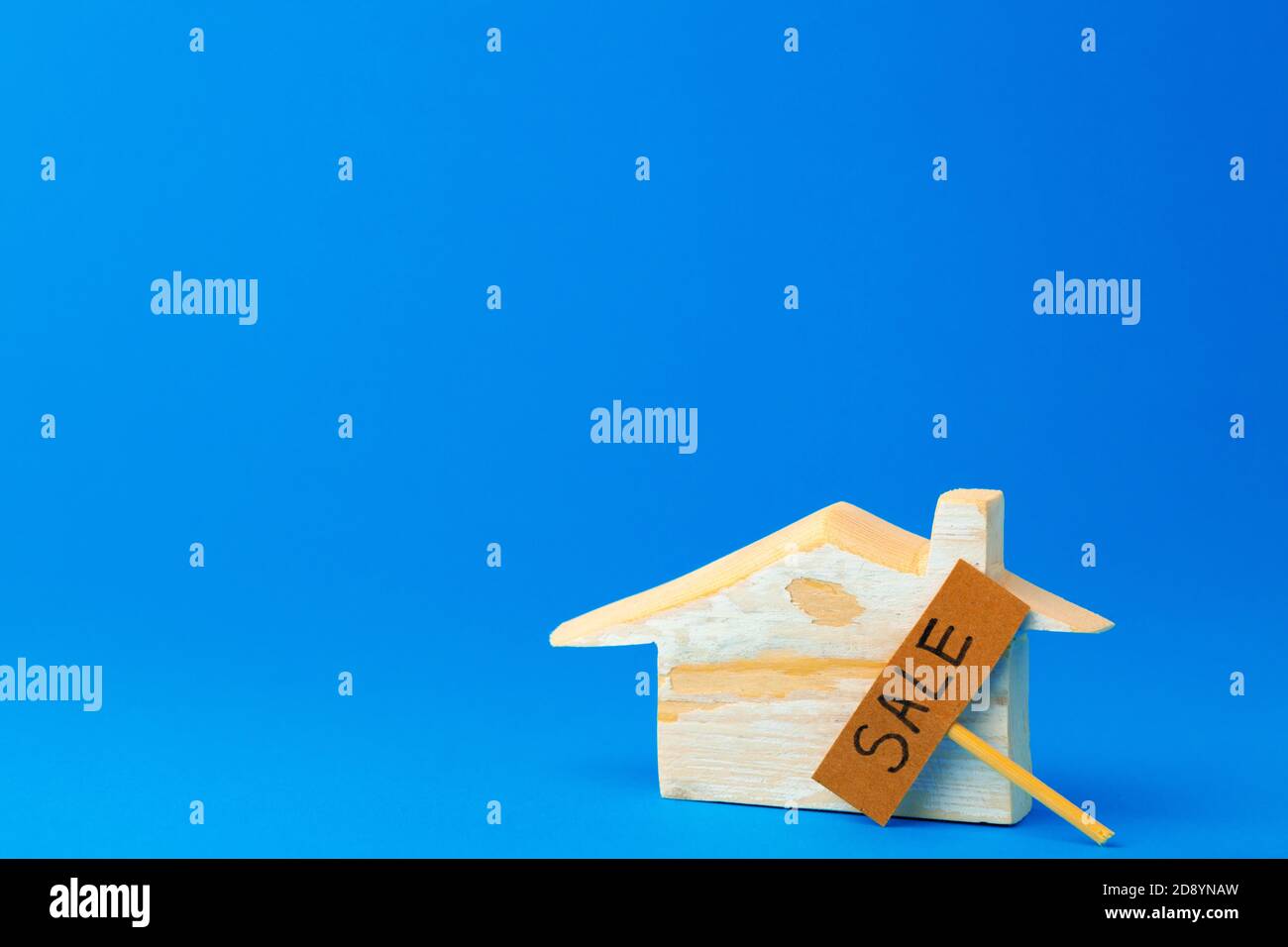 Wooden house model and for sale sign Stock Photo - Alamy