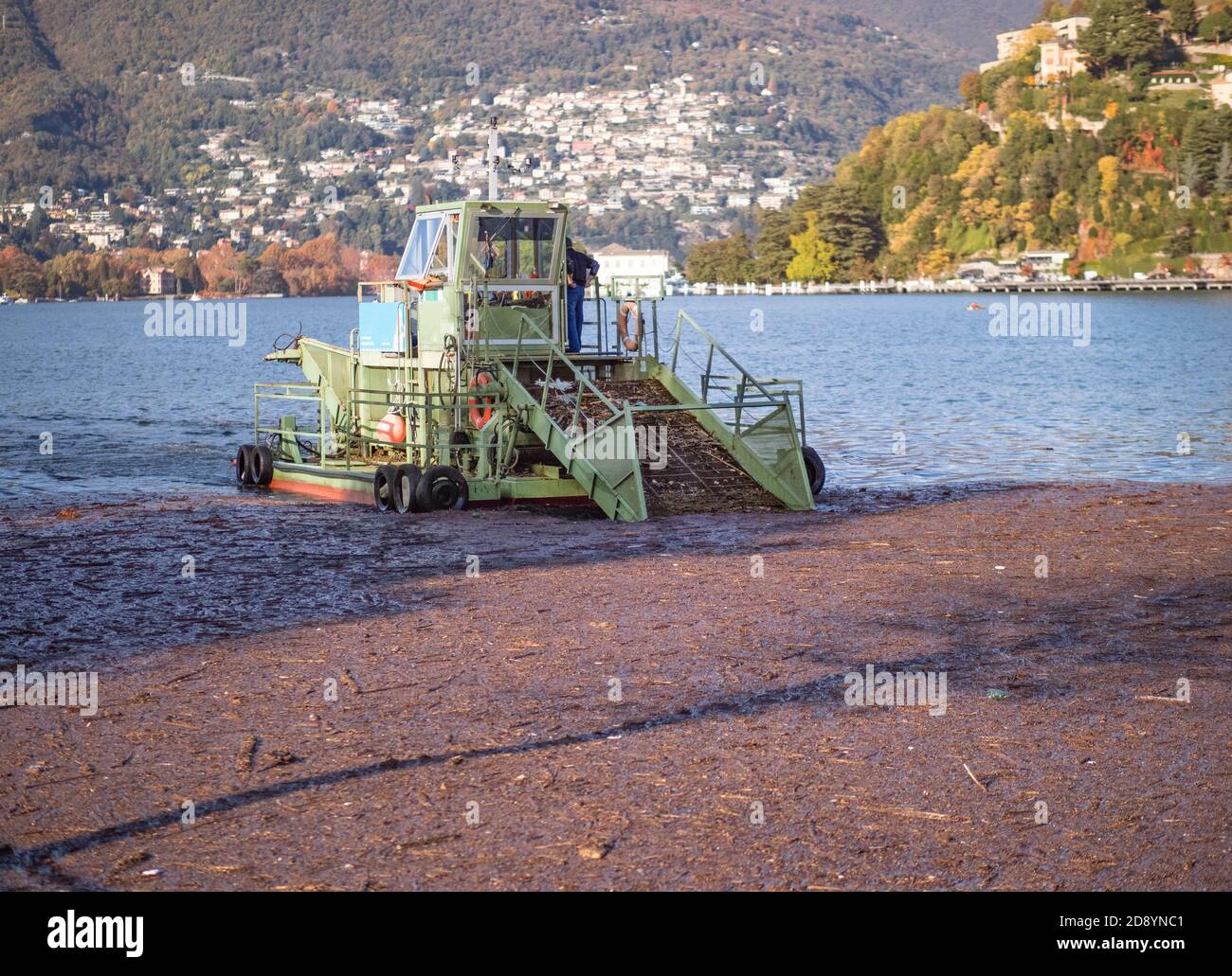 Sweeping boat collects debris and branches brought by heavy rains on ...