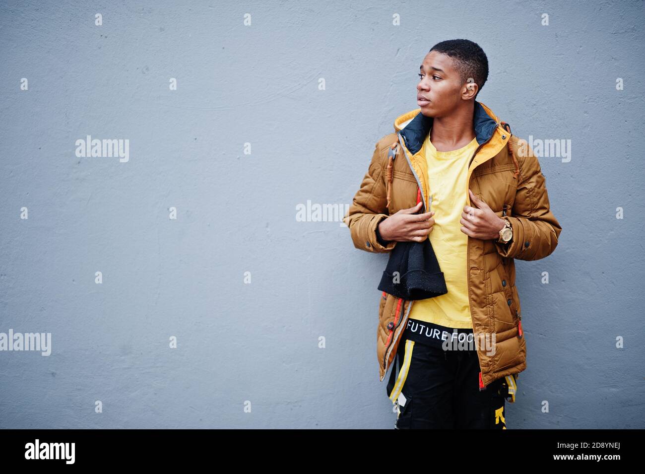 African man wear on jacket at cold weather posed outdoor against grey ...