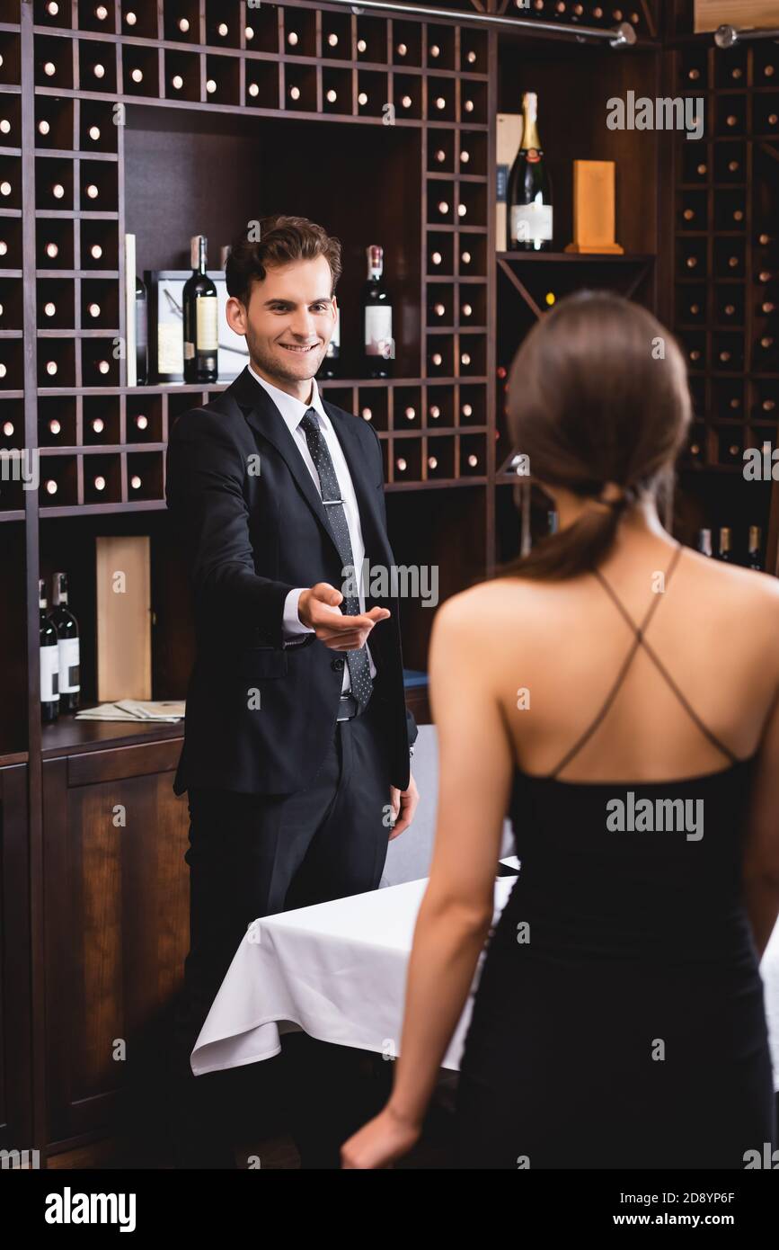 Selective focus of young man in suit meeting girlfriend in restaurant ...