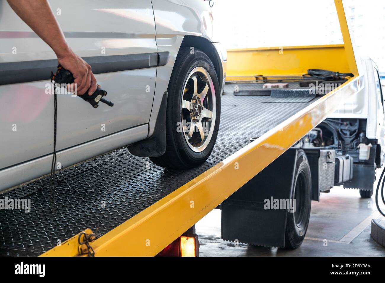 Closeup on car towed onto flatbed tow truck with cable Stock Photo - Alamy
