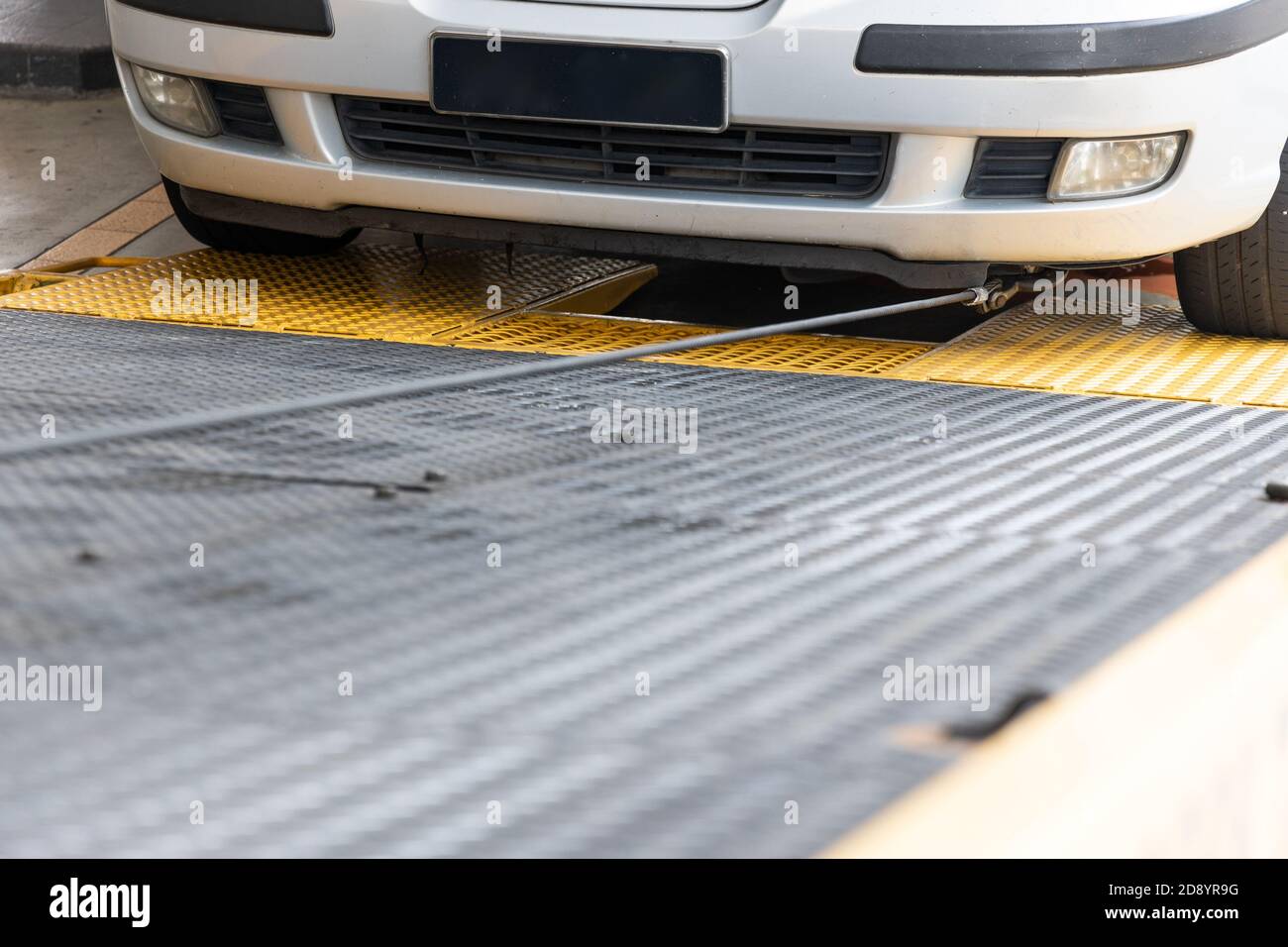 Closeup on car towed onto flatbed tow truck with cable Stock Photo - Alamy