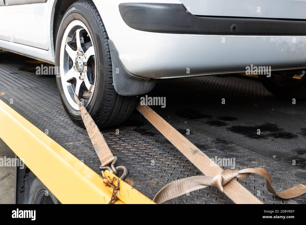 Car tied with security strap on flatbed tow truck Stock Photo - Alamy