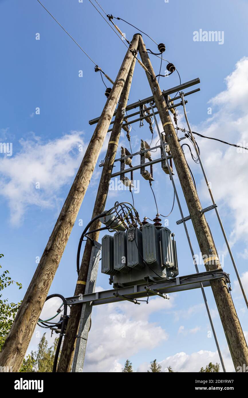Electrical post by the road with power line cables and transformers ...