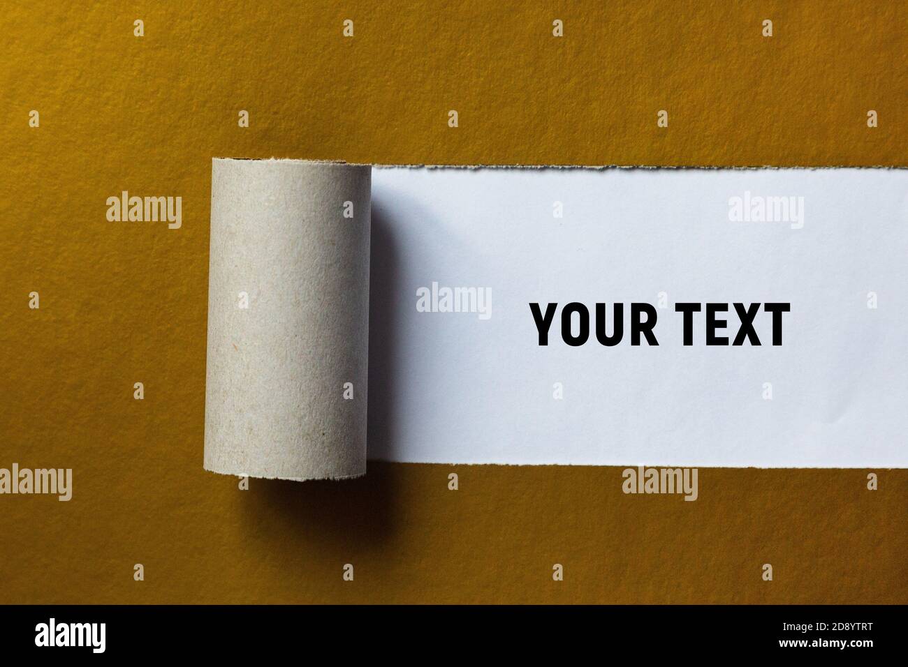 A torn strip of a sheet of golden brown paper is rolled into a roll ...