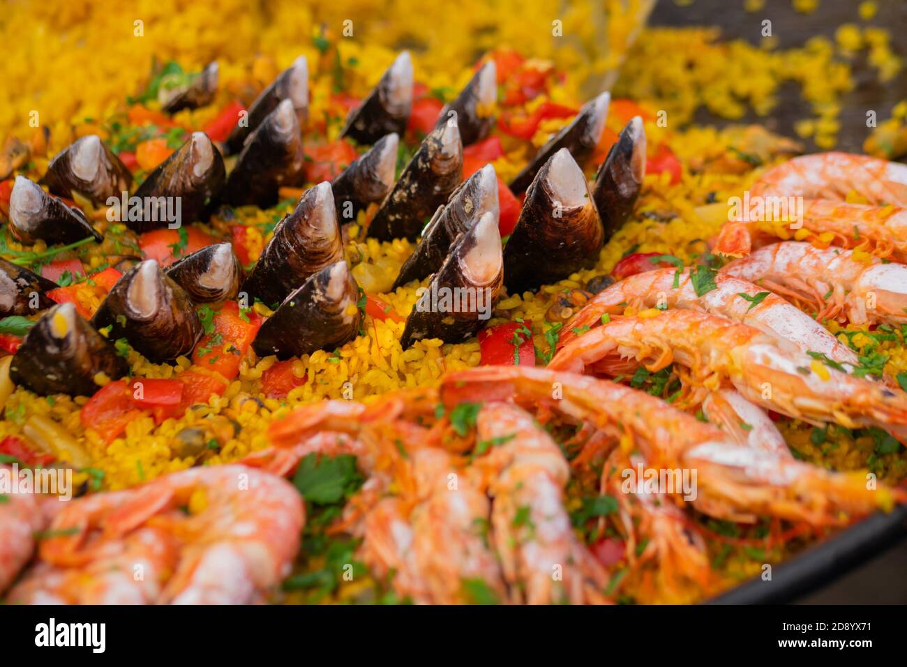 Cooked yellow paella with shrimp, mussel, rice, spice, saffron in huge ...