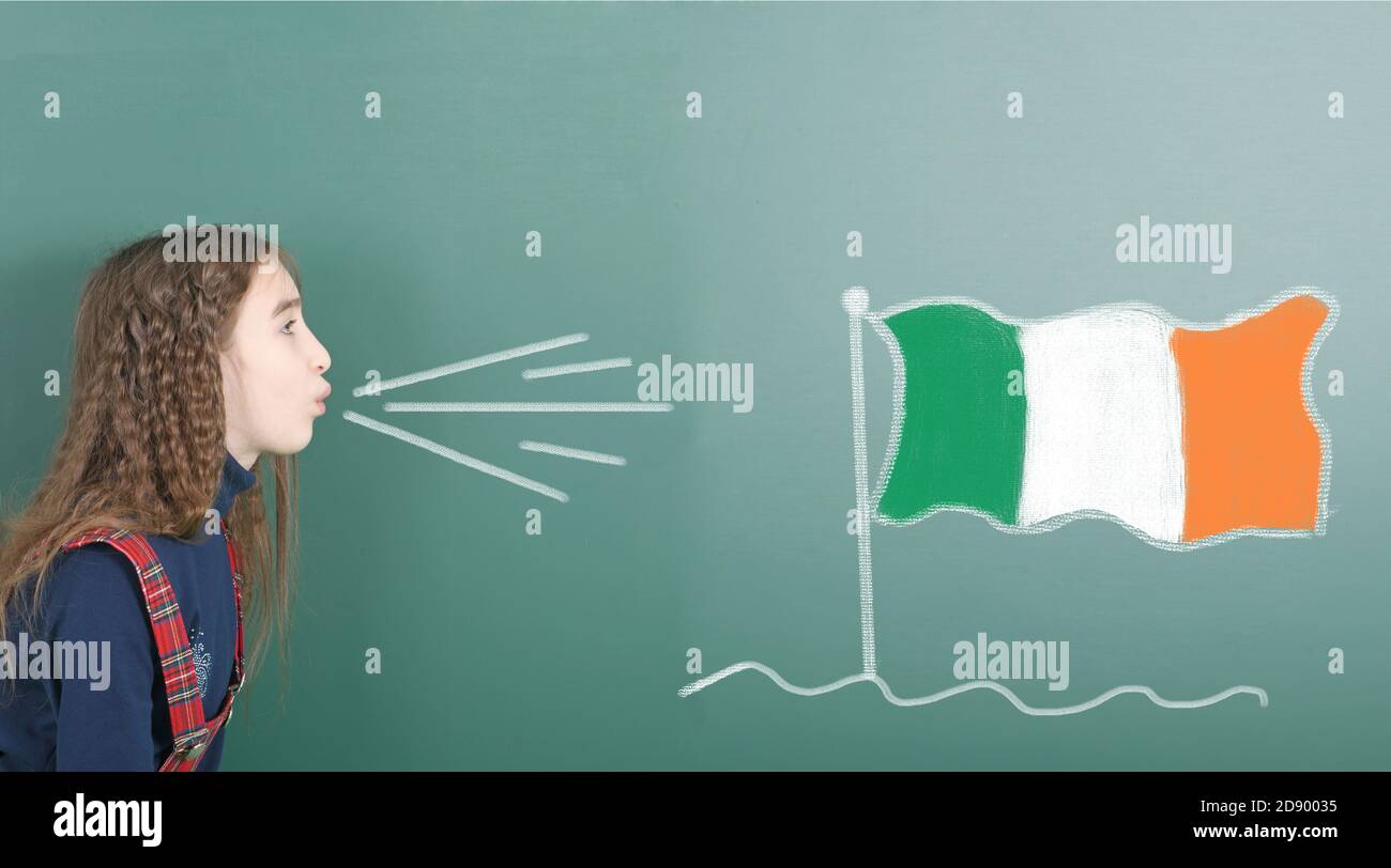 Pre-adolescent girl blowing on the school board drawn on the blackboard ...