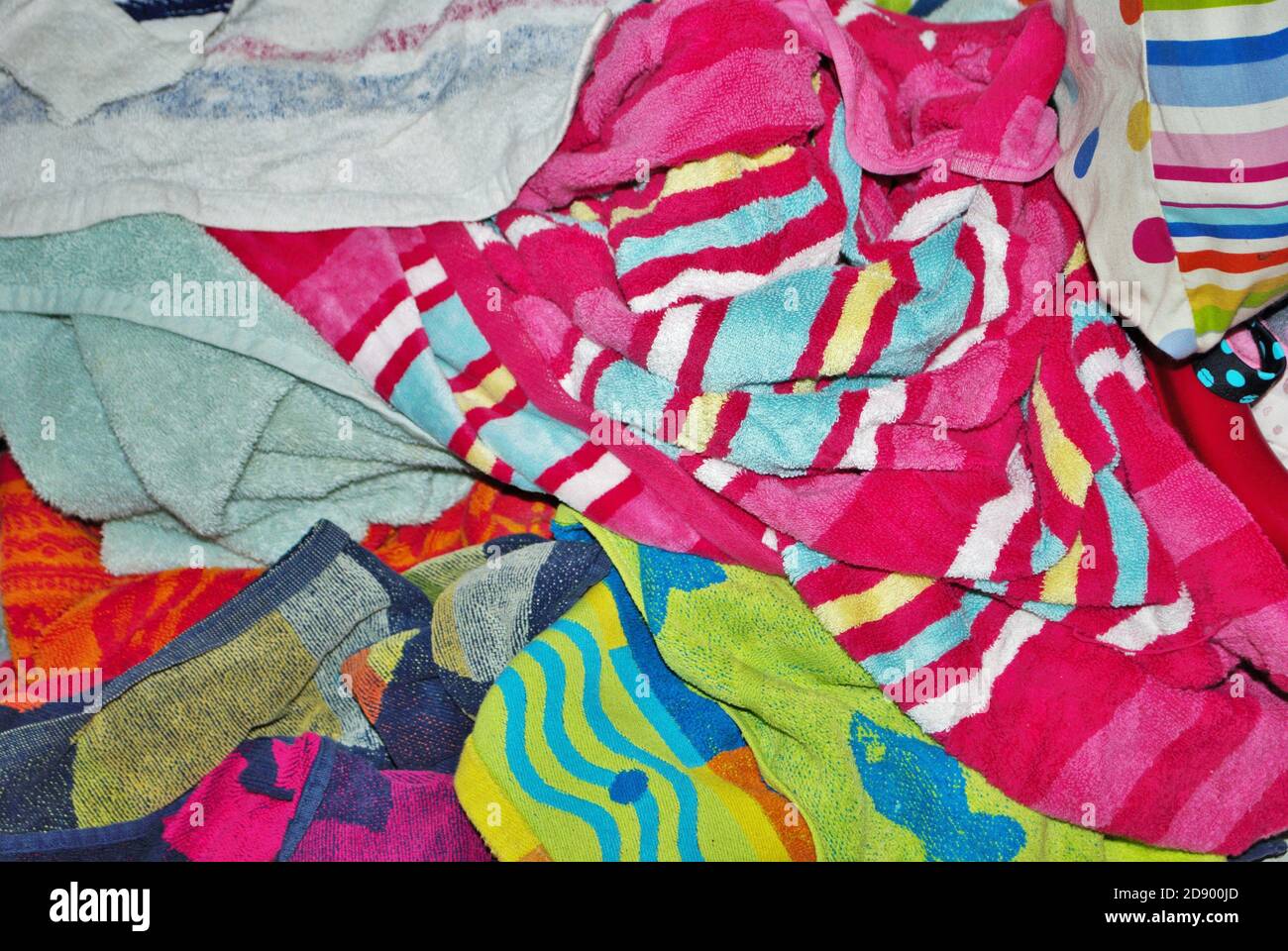 Pile of dirty towels that need to be washed in a basement laundry room ...