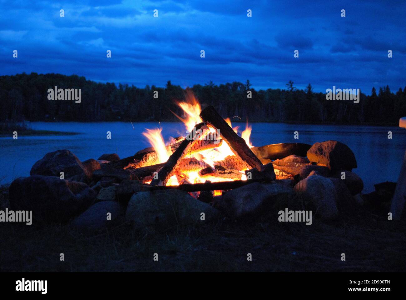 camp fire burning in a fire pit next to the lake Stock Photo - Alamy