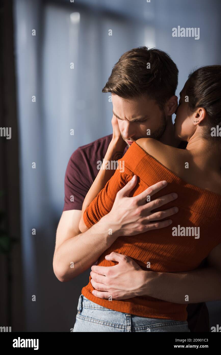 back view of young woman embracing and calming upset boyfriend Stock ...