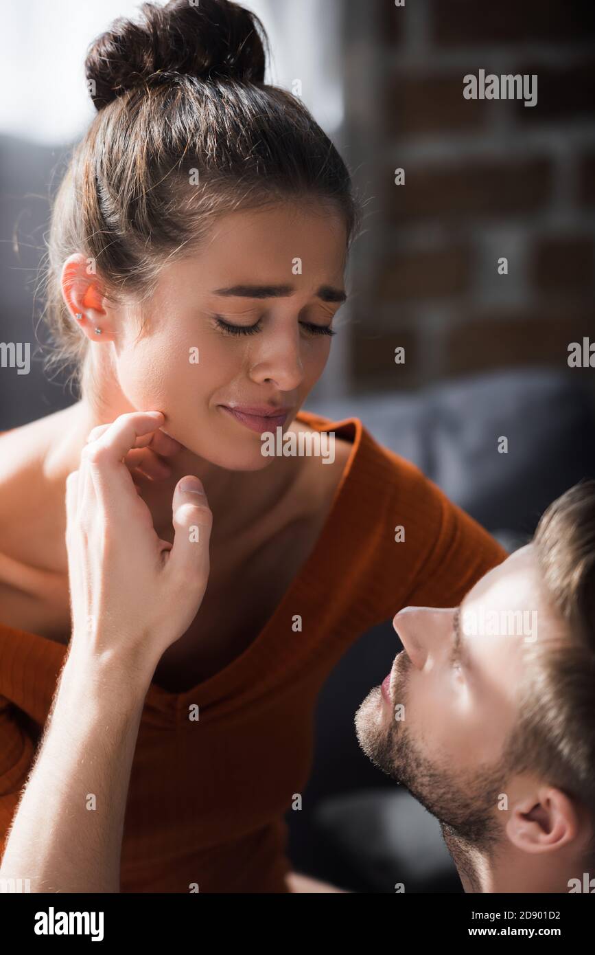 responsive man touching face of crying girlfriend while calming her at ...