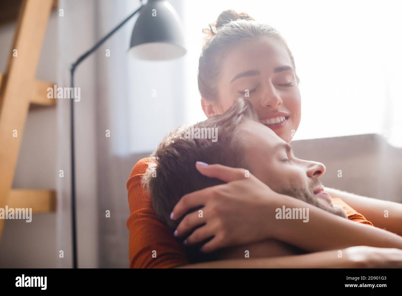 happy woman with closed eyes hugging head of beloved man at home Stock ...