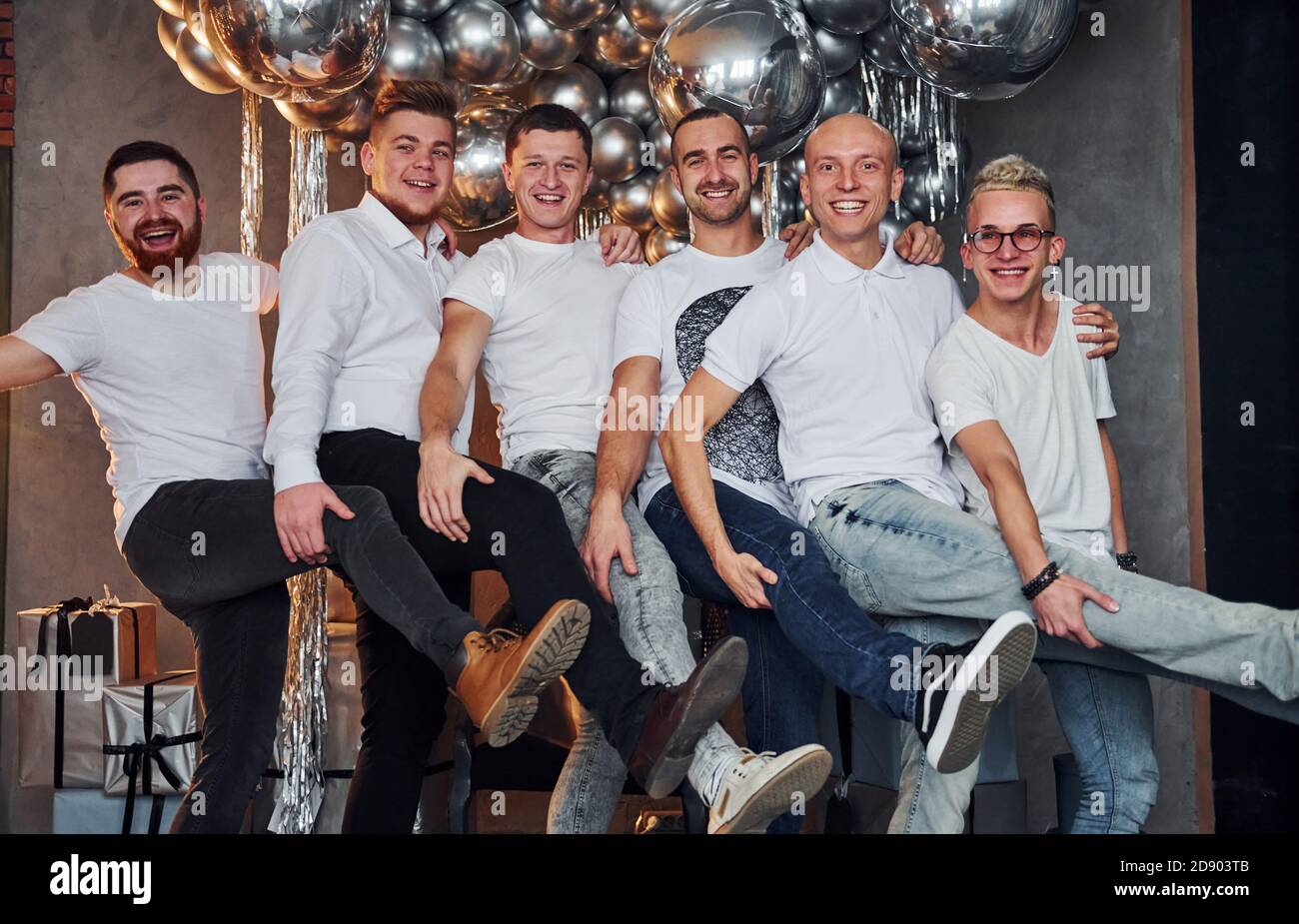 Group of cheerful men standing together in christmas decorated room and ...