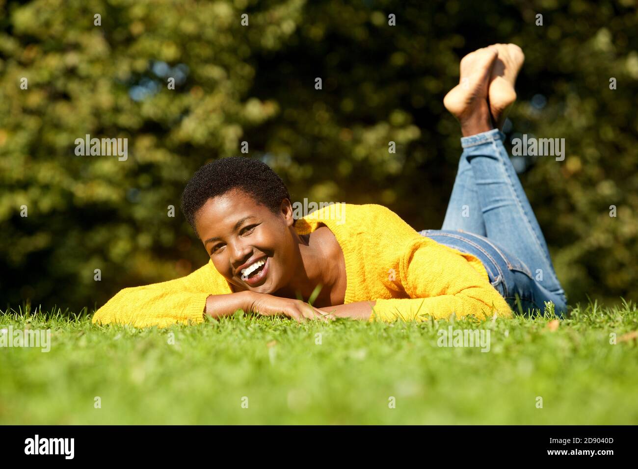 Portrait of happy young african american woman relaxing in park Stock ...