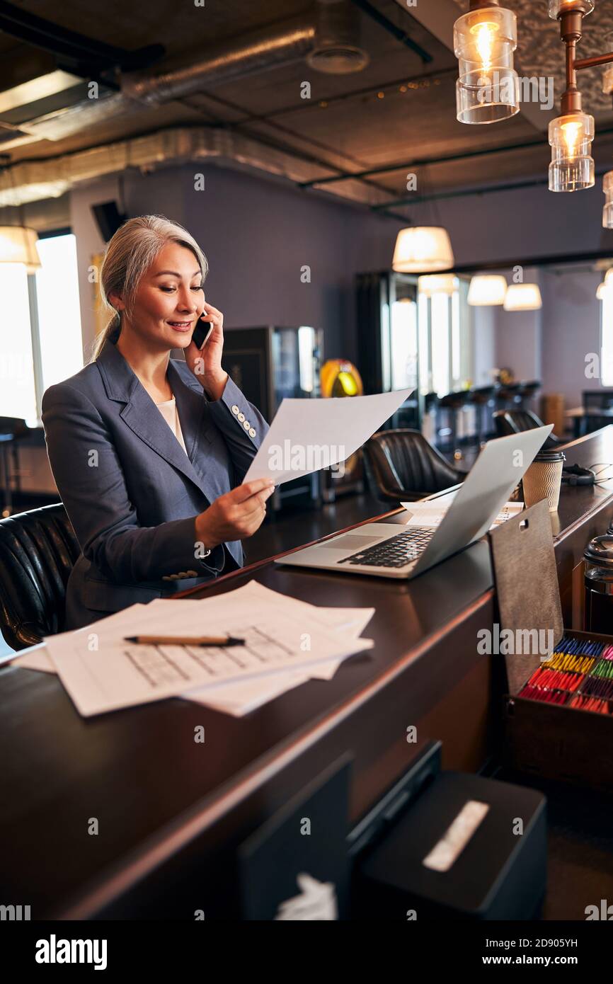 Cheerful businesswoman having phone conversation at work Stock Photo ...
