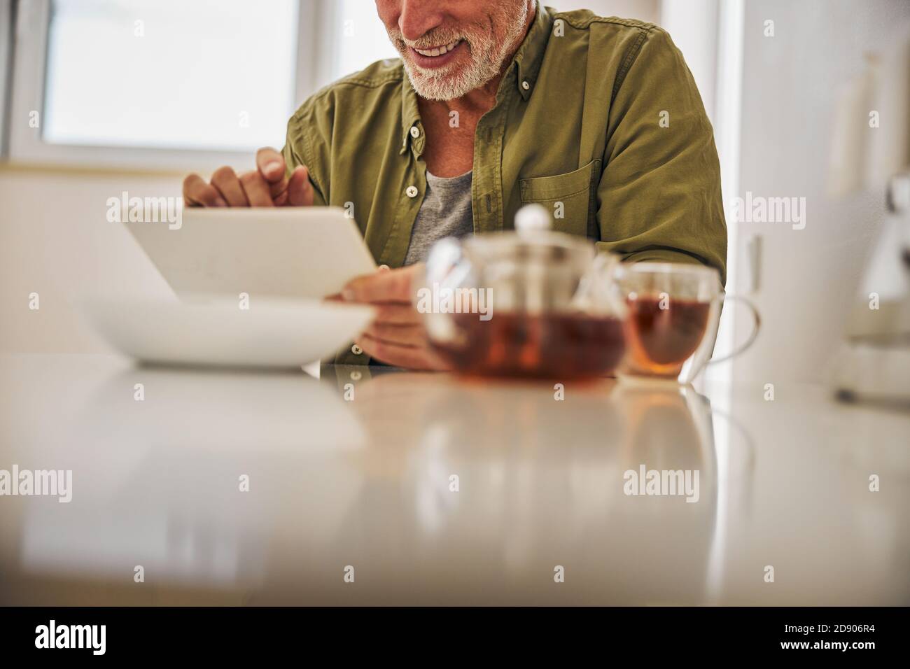 Aging bearded gentleman touching tablet screen and having tea Stock ...