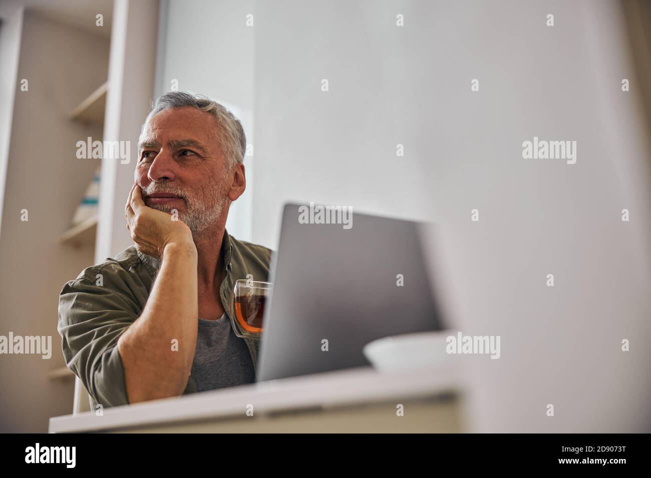 Pensive-looking aging man sitting in front of computer screen Stock ...