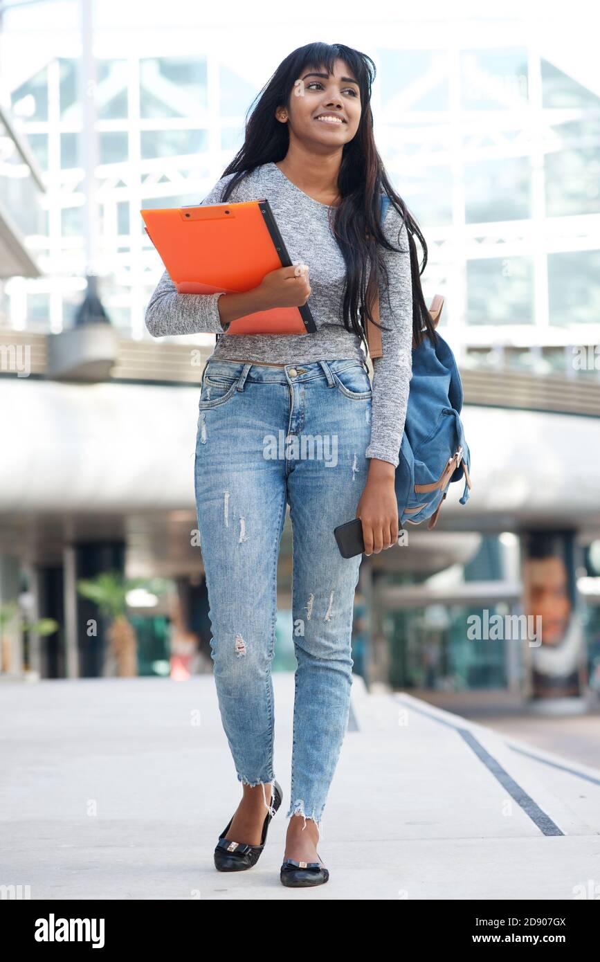 Full body portrait of Indian female college student walking in city ...