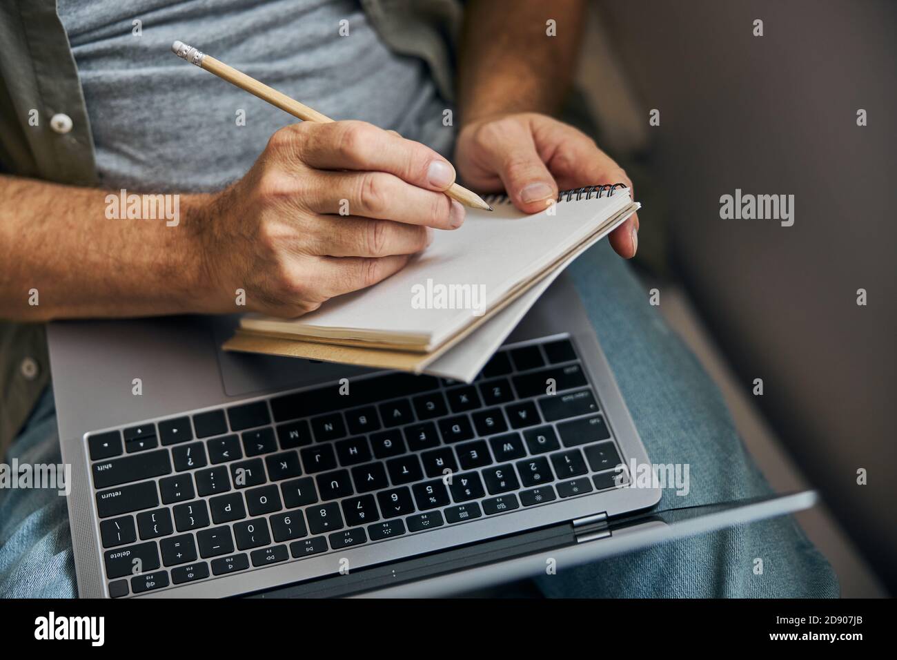 Diligent man taking notes while working from home Stock Photo - Alamy