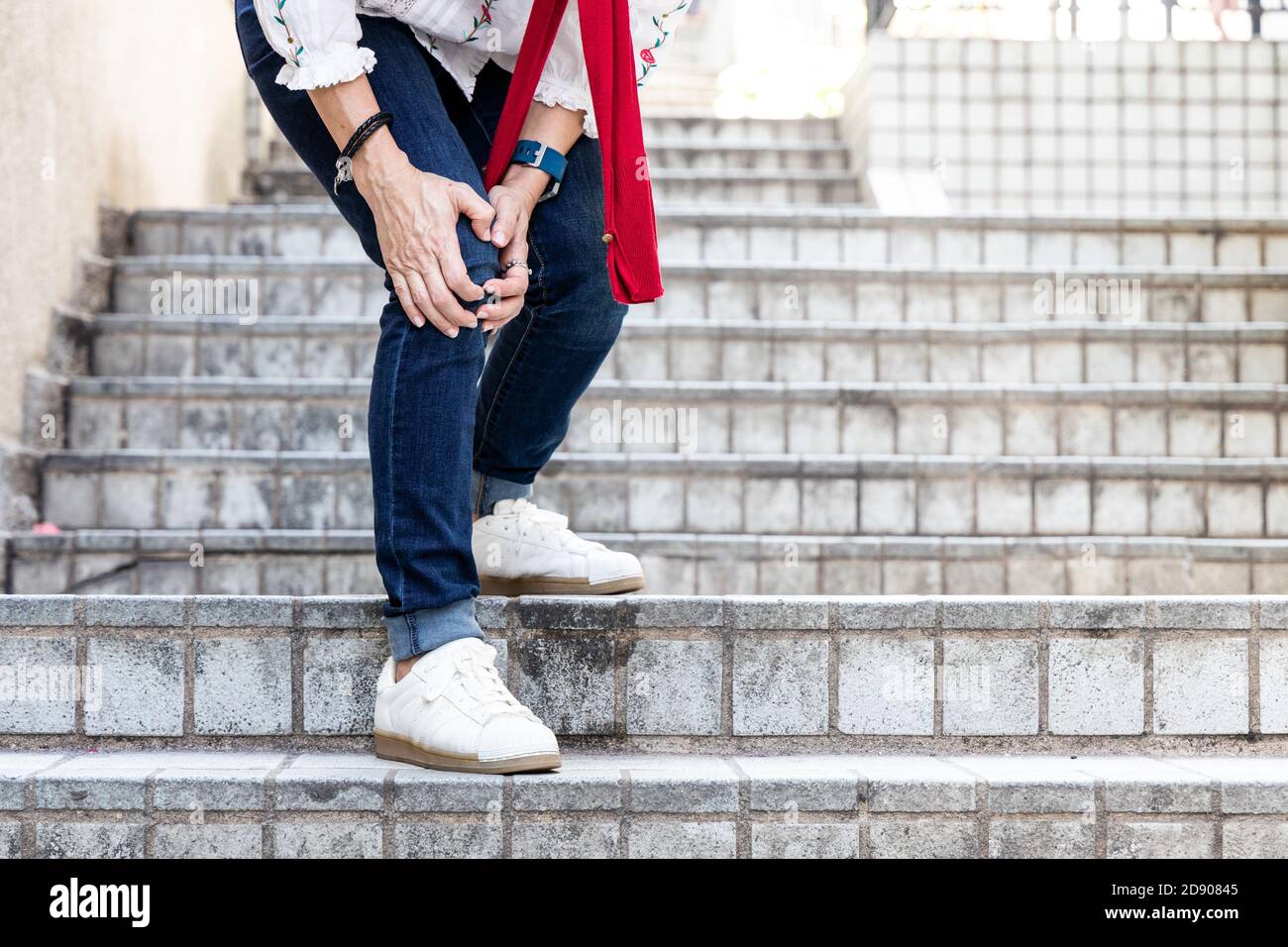 Woman with painful knee struggle walking down flight of stairs Stock ...