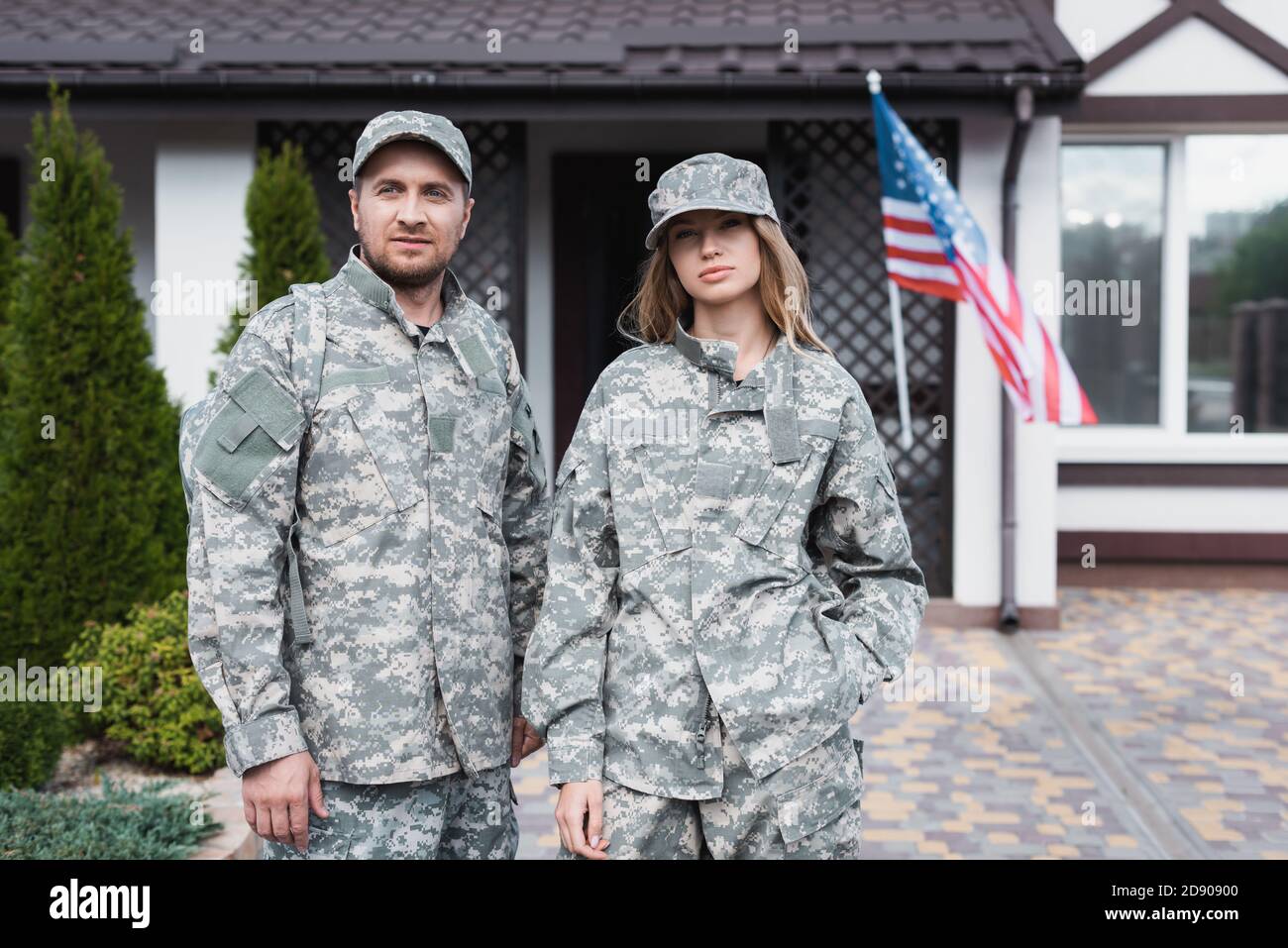 Military couple in uniforms standing together and looking at camera ...