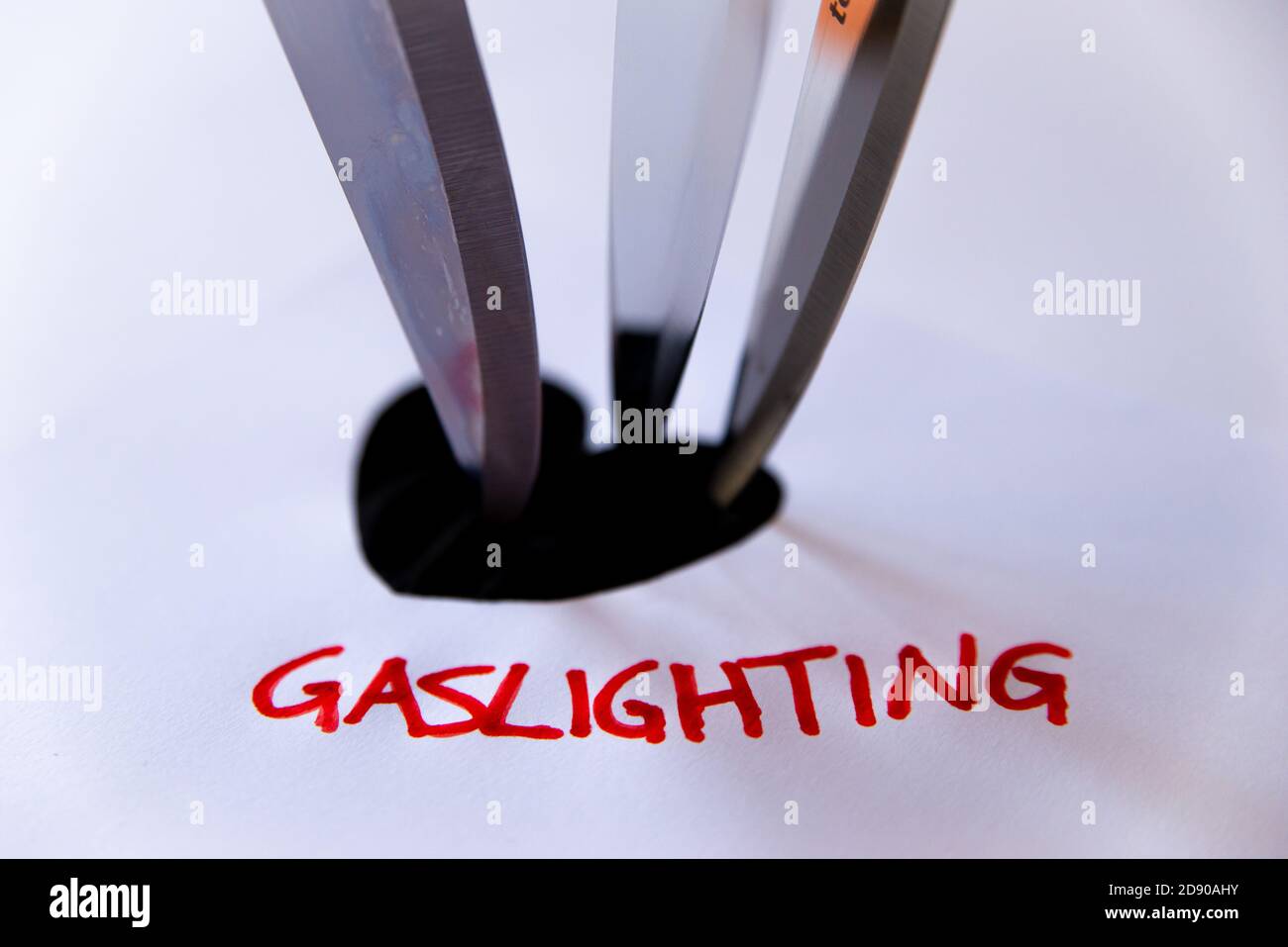 Word "Gaslighting", written in red on white paper, with heart design ...