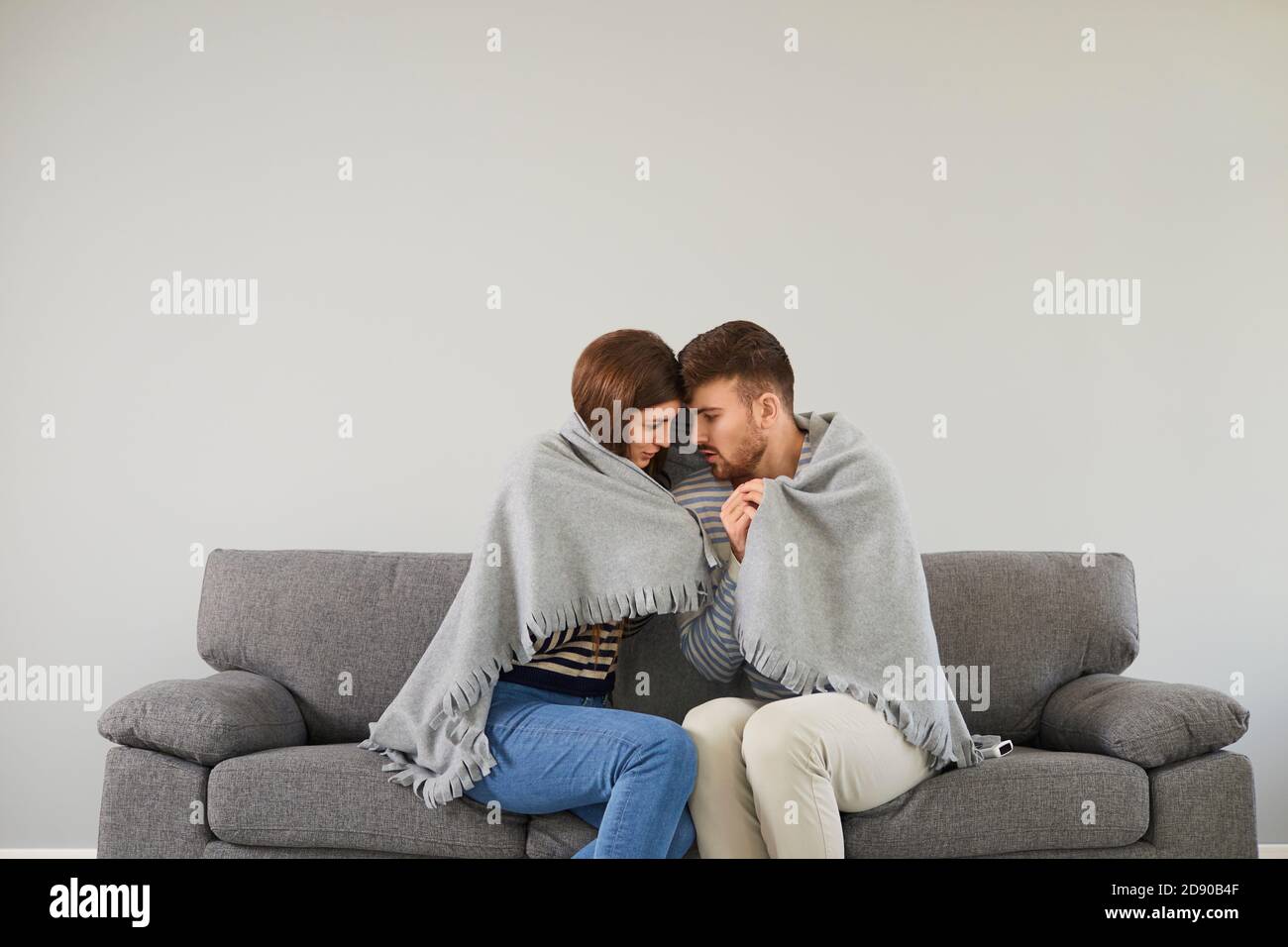 Freezing couple in cool room cuddling in plaid Stock Photo - Alamy