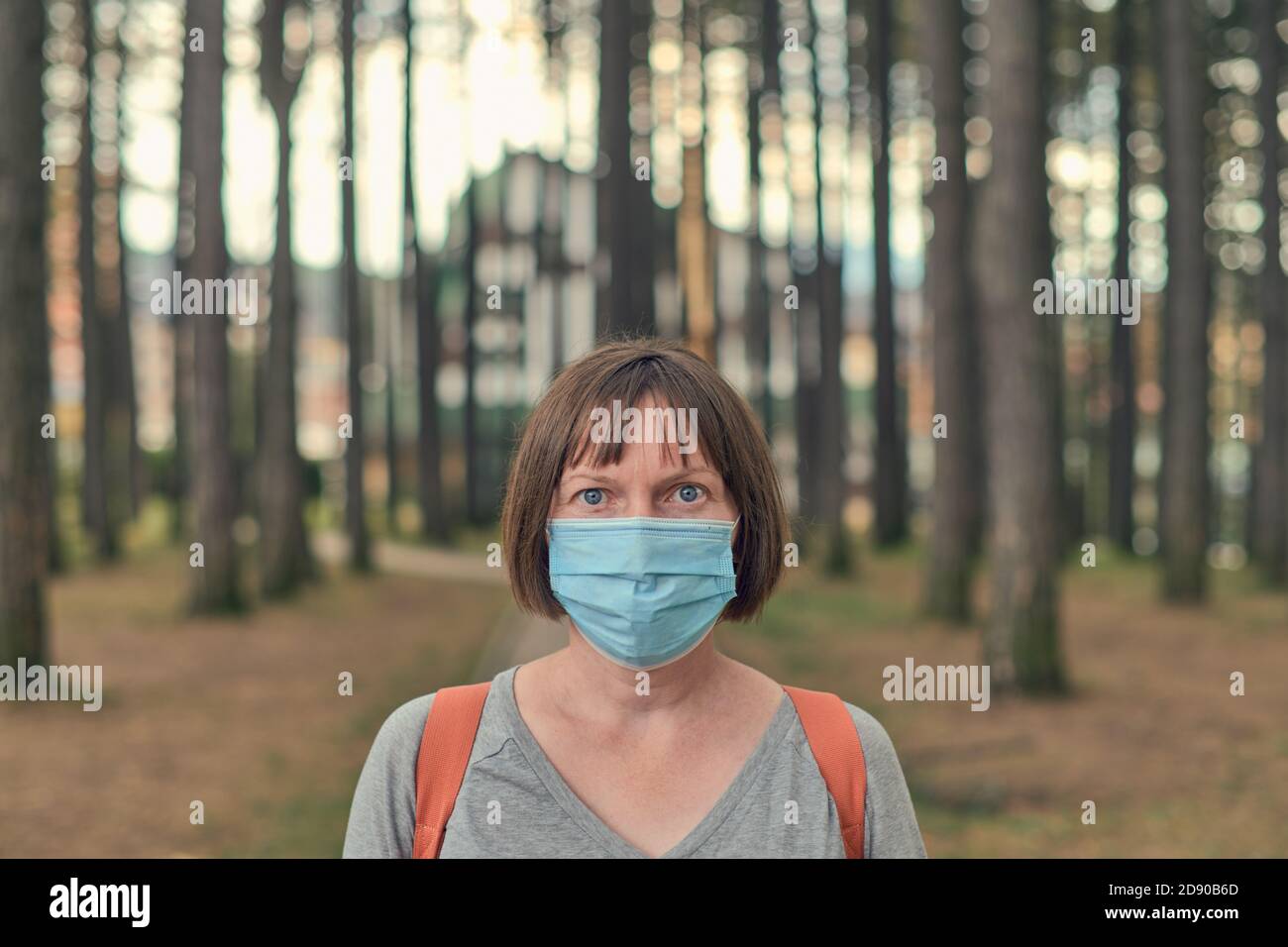 Casual woman in everyday protective face mask concept posing in park ...