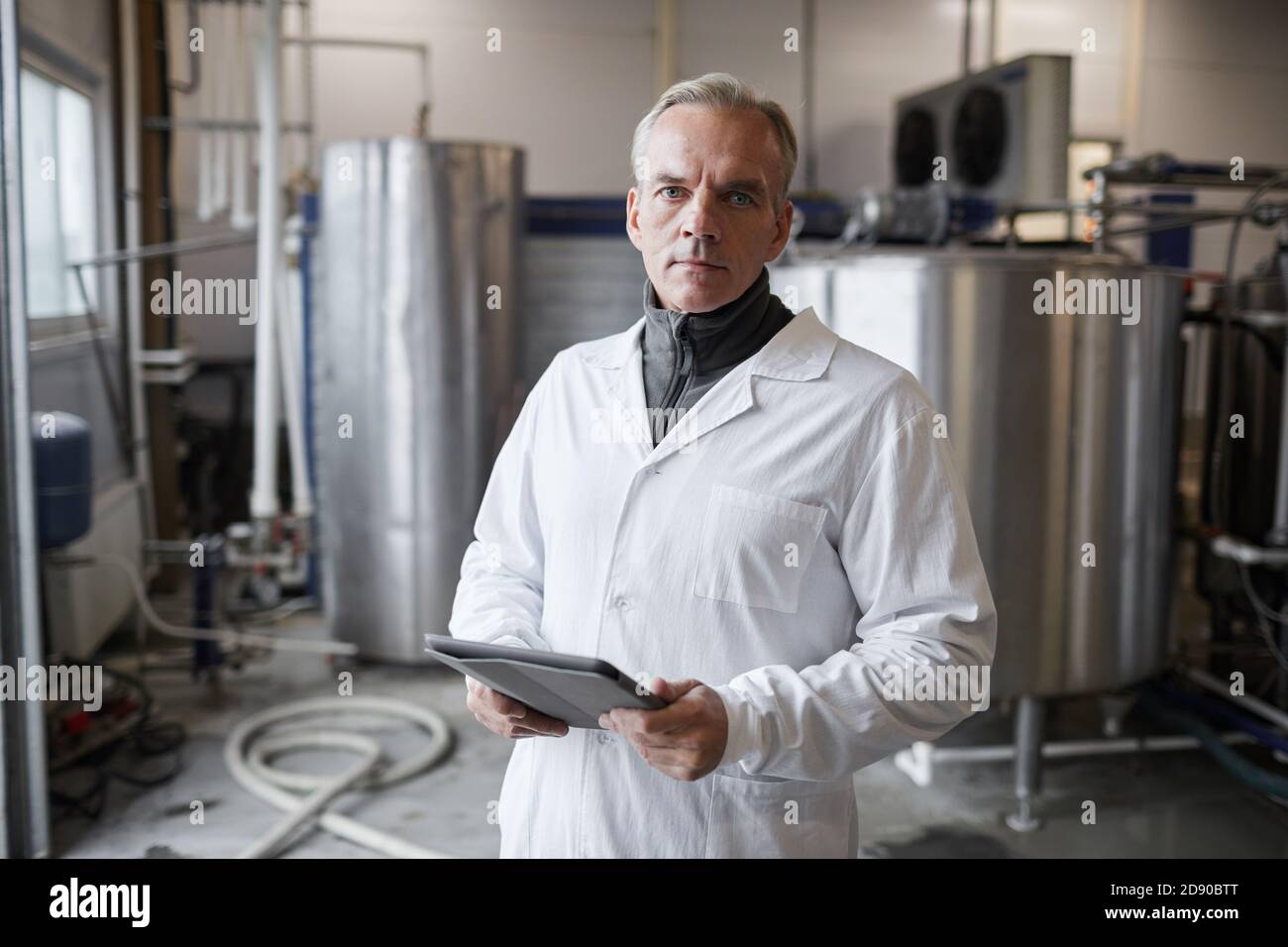 Waist up portrait of mature man wearing lab coat posing against ...