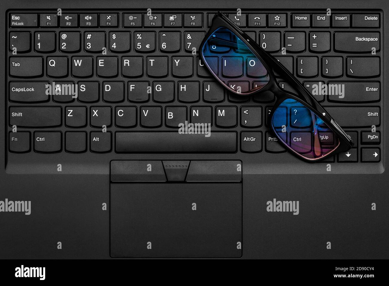 Black framed glasses on the computer keyboard, top view Stock Photo - Alamy