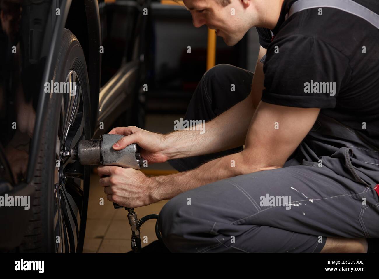 male is repairing car wheel alone, using special tools for repairing ...