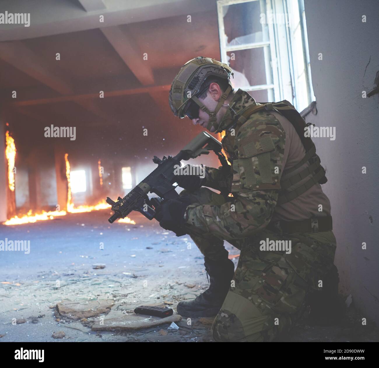 soldier in action near window changing magazine and take cover Stock ...