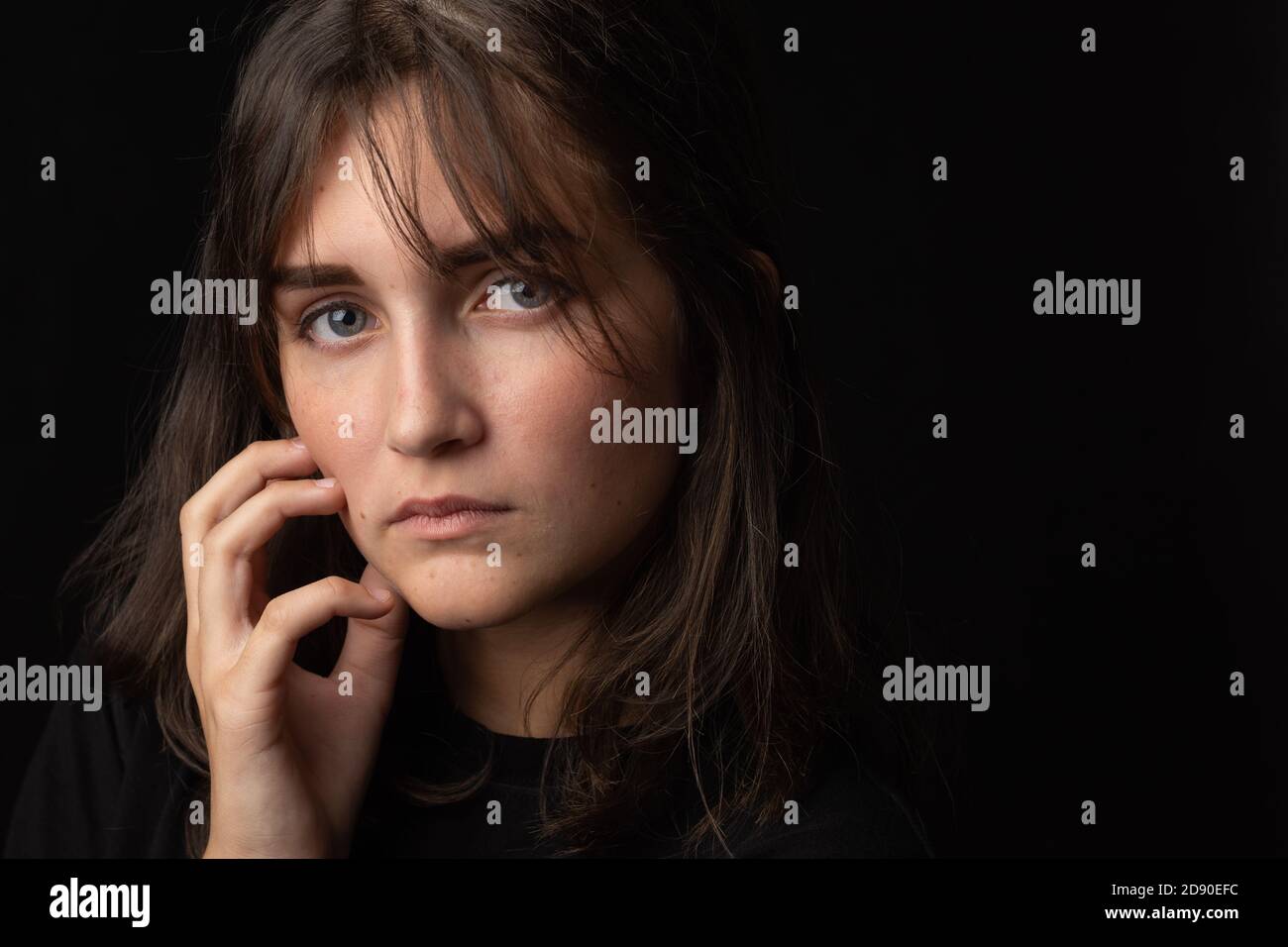 Portrait of a beautiful girl with a thoughtful look on a black ...
