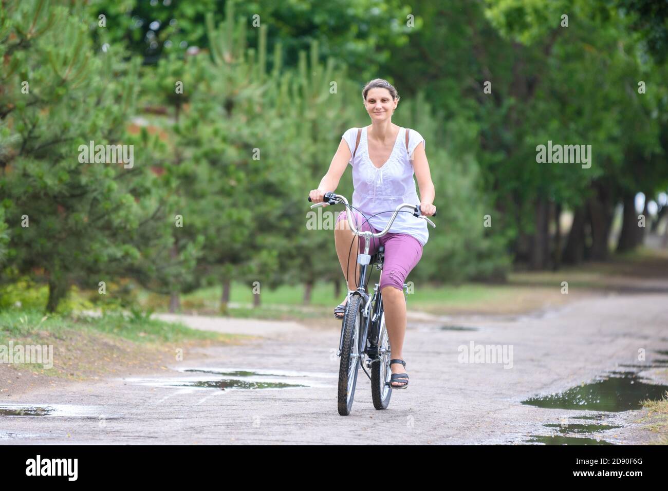 Girl riding a bicycle on a rainy warm summer morning Stock Photo - Alamy