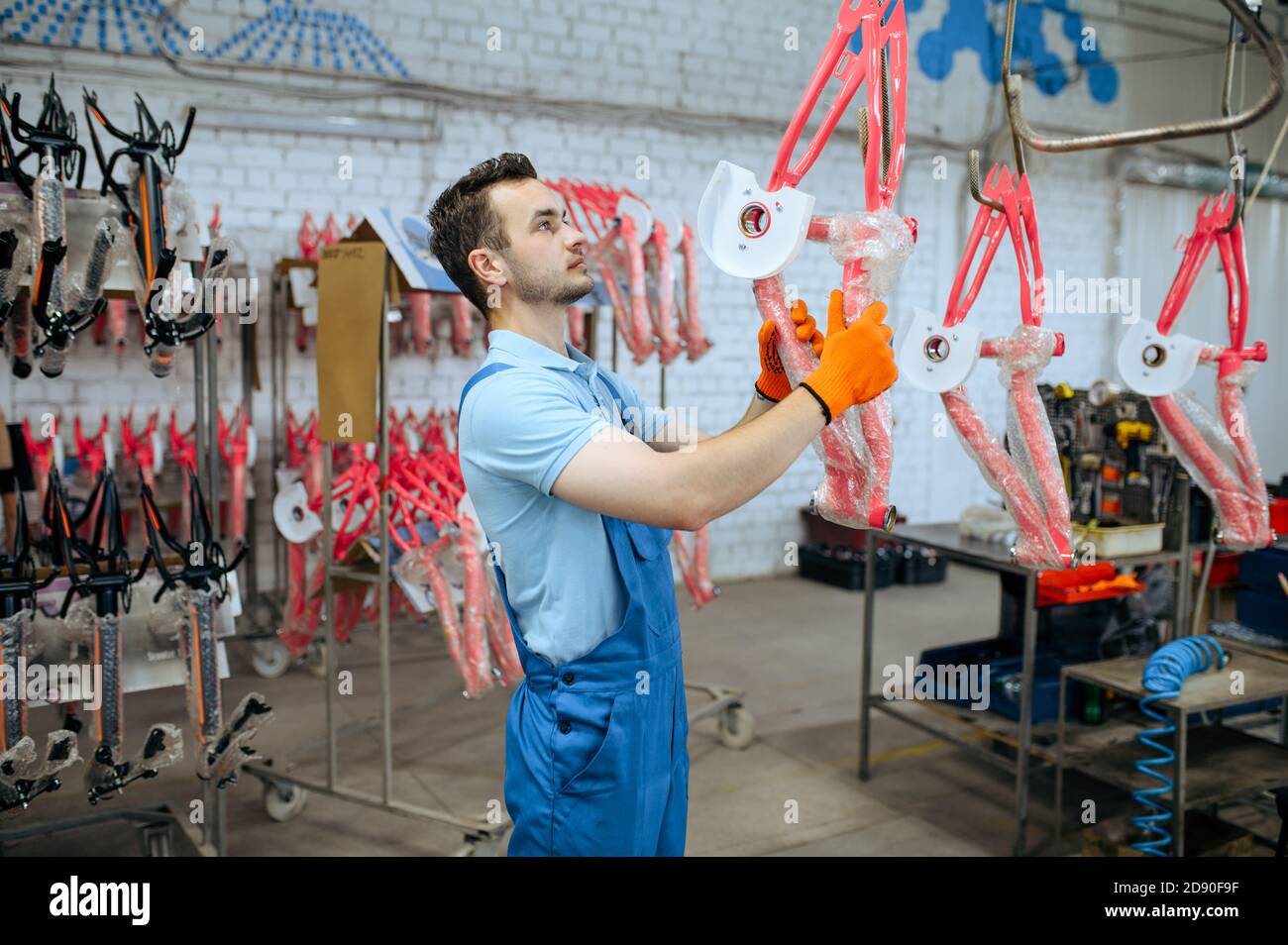 Bicycle factory, worker holds bike frame Stock Photo - Alamy