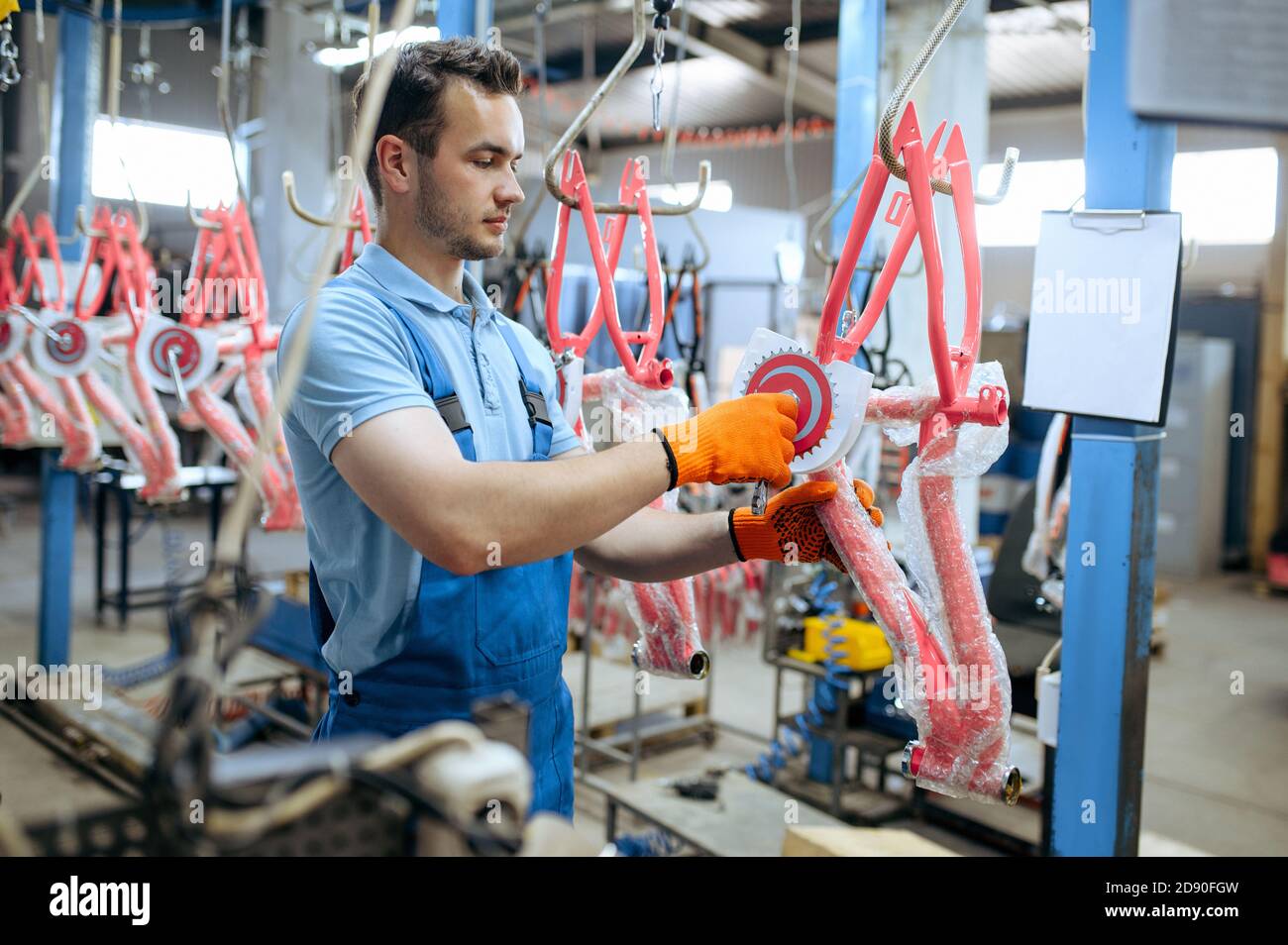 Bicycle factory, worker holds kid's bike frame Stock Photo - Alamy