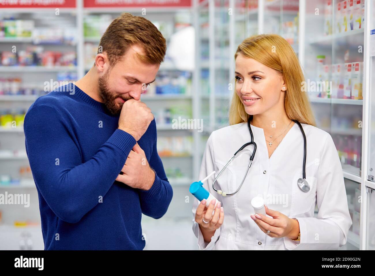 young caucasian helpful female druggist dealing with a male customer ...