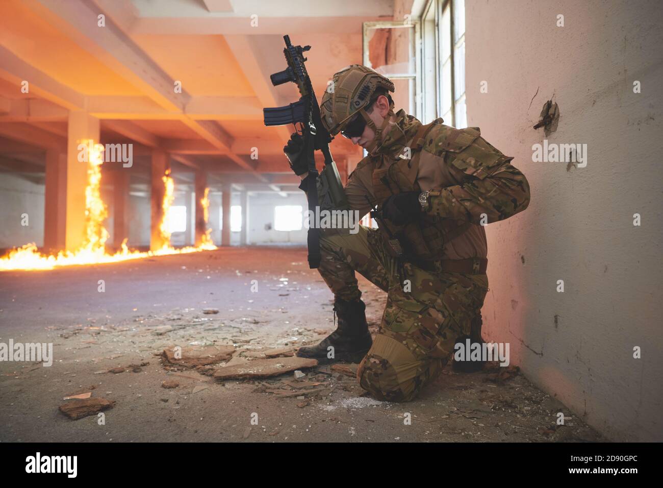 soldier in action near window changing magazine and take cover Stock ...