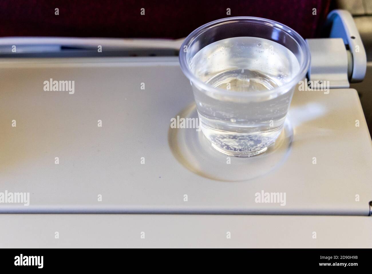 Inflight cabin glass of water on table. Drink to prevent dehydration ...