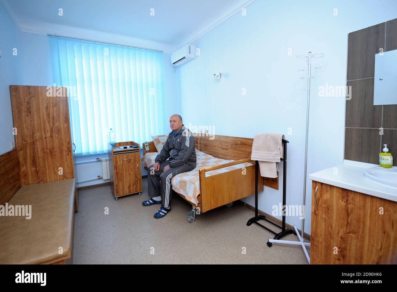 Man sitting on a bed of a hospital room of a surgical unit Stock Photo ...