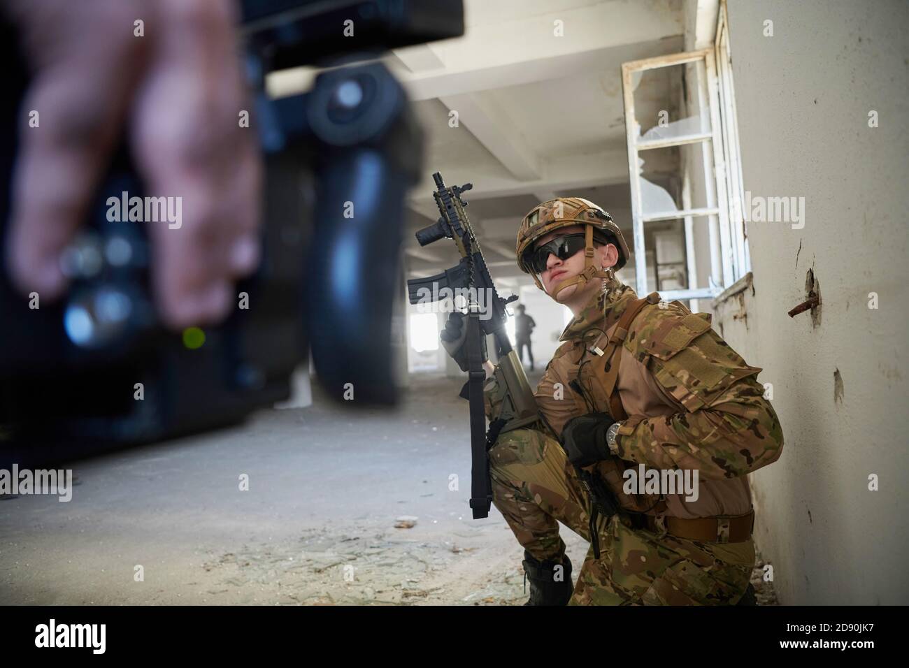 soldier in action near window changing magazine and take cover Stock ...