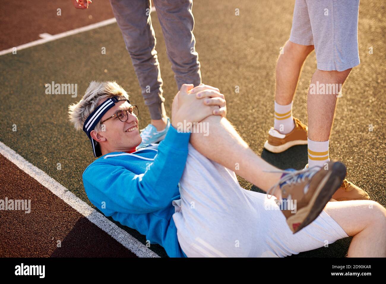 basketball player fell to his knee on the court outdoors. caucasian ...