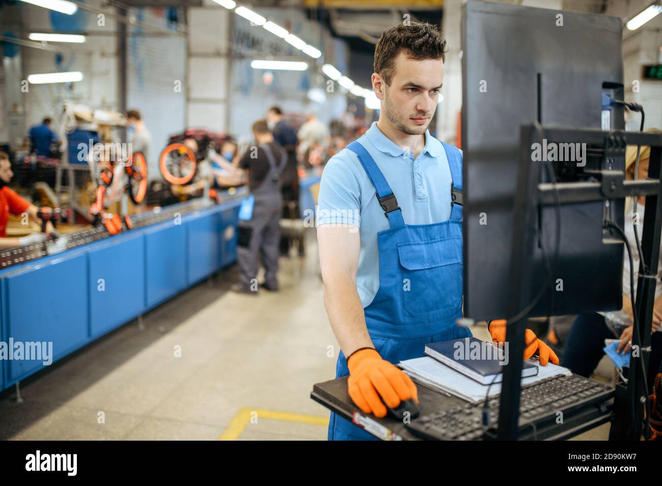 Bicycle factory, worker manages bike assembly line Stock Photo - Alamy