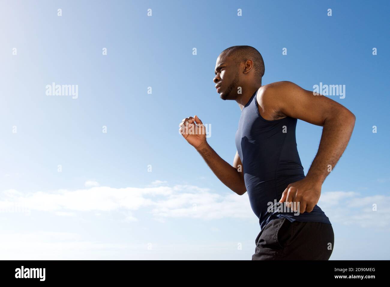 Side portrait of active young black man running outdoors Stock Photo ...