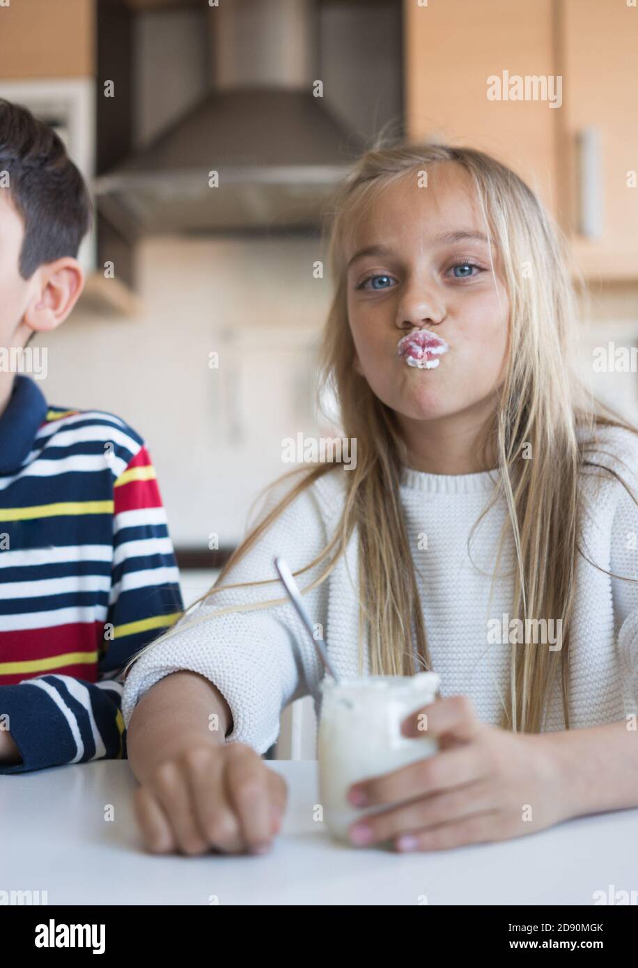 Happy children eating a yogurt in the dining room of their house Stock ...