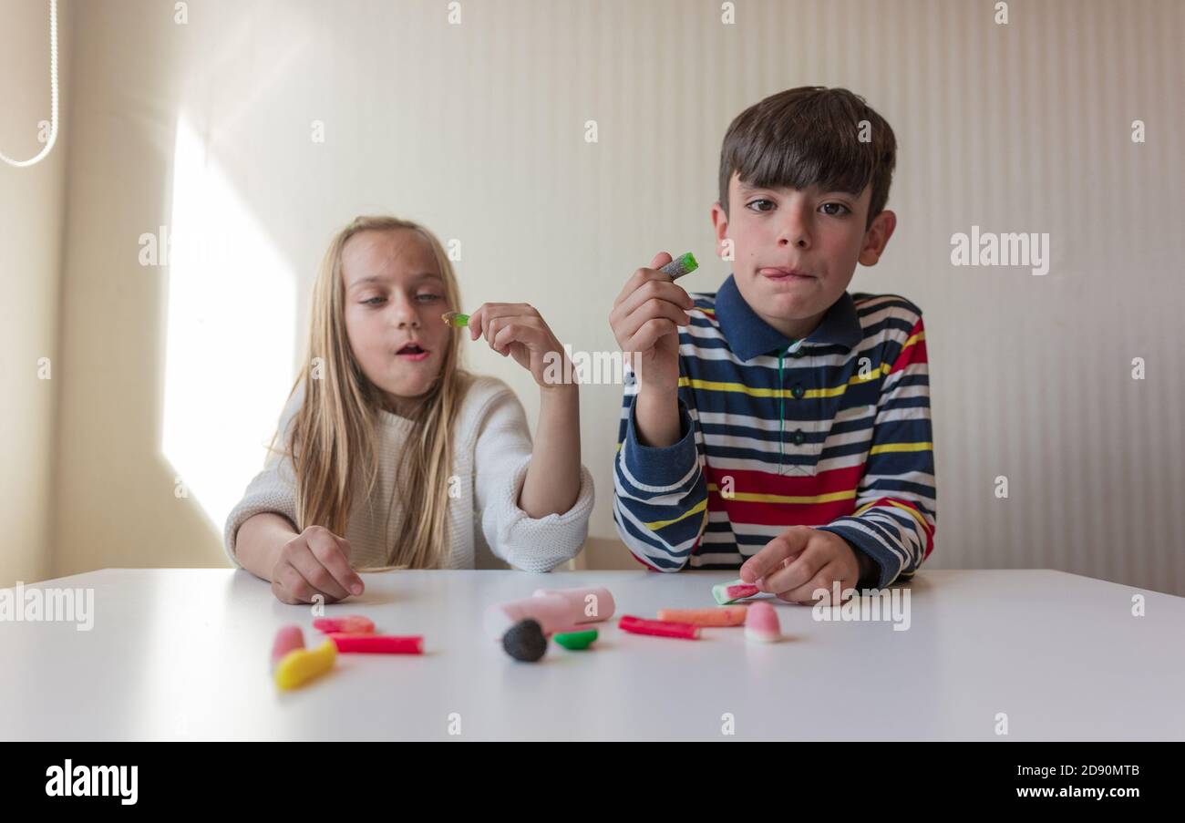 Children eating candy at the dining table while you play Stock Photo ...