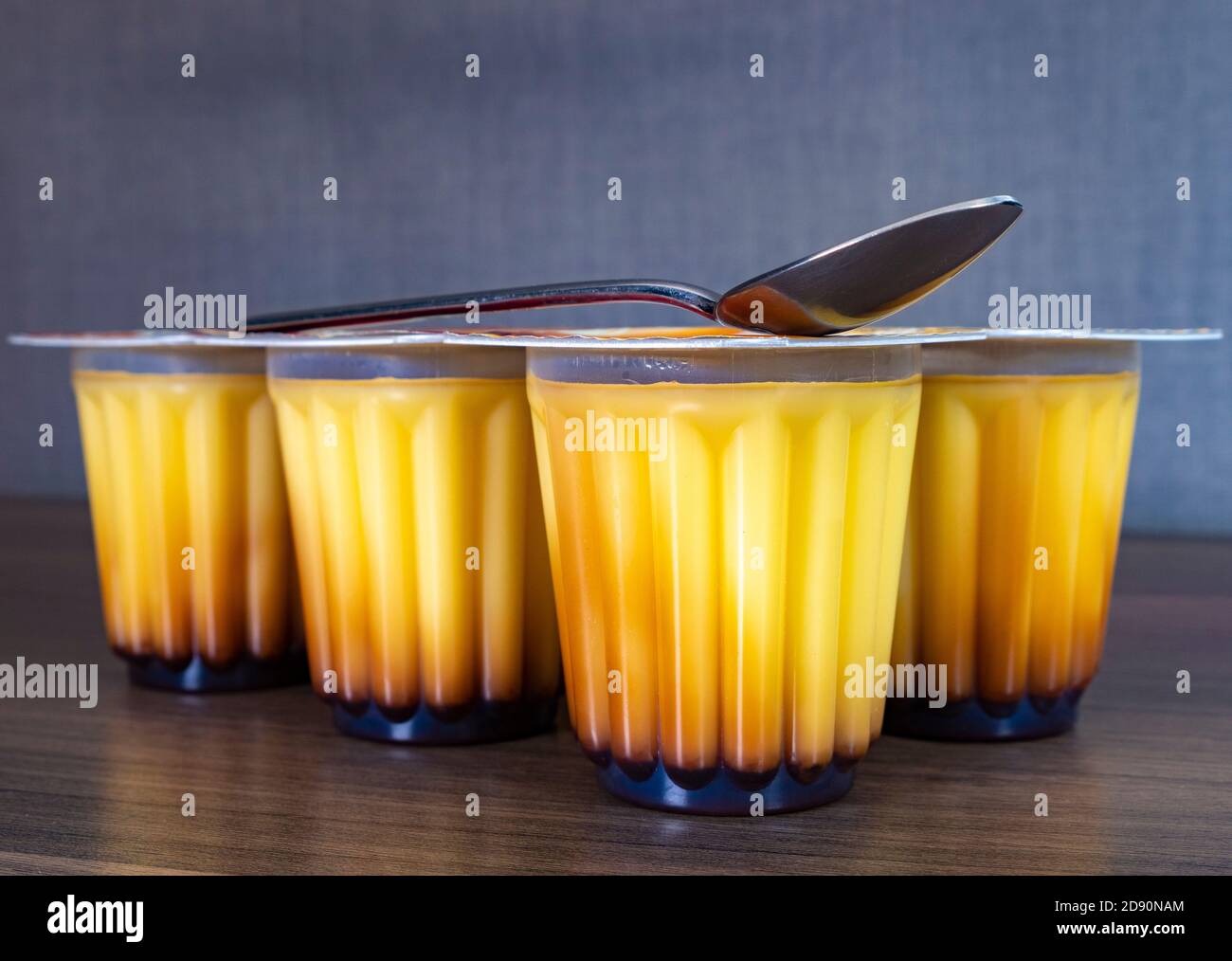 Closeup POV shot of a retail six pack of creamy caramel dessert pots ...