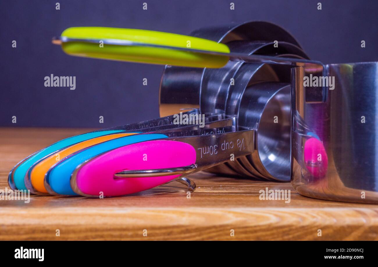 Closeup POV shot of a set of different sized, stainless steel measuring ...