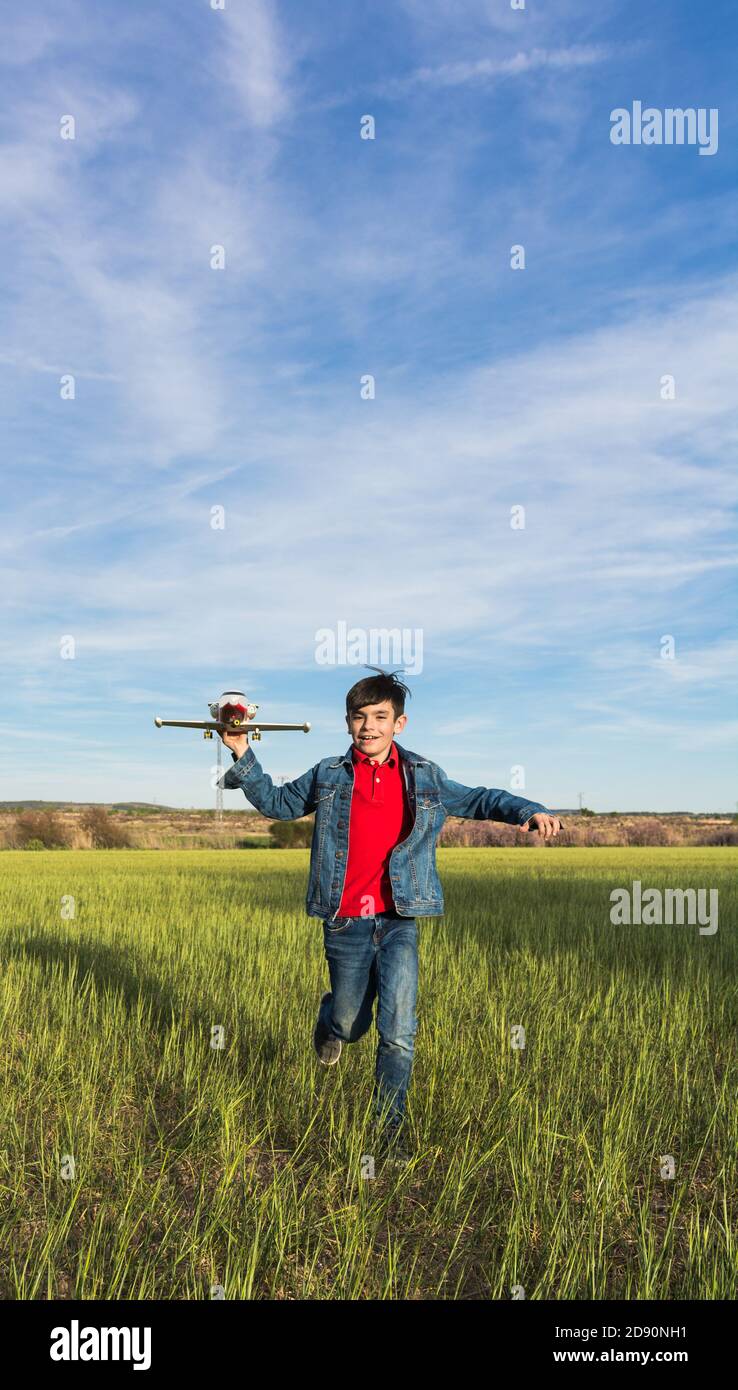 Boy running with a plane in a park while dreaming of being a pilot ...